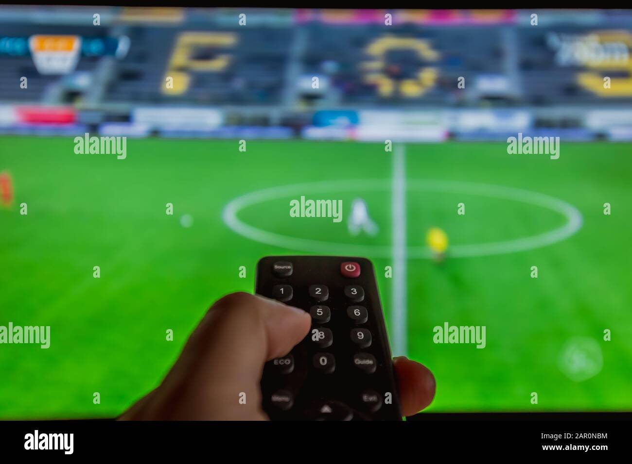 watching soccer at home tv with remote control in hand, entertainment ...