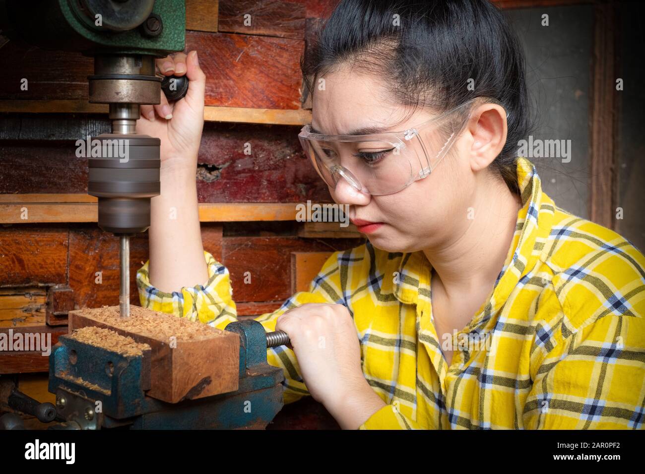 Women standing is craft working drill wood at a workbench with Drill ...