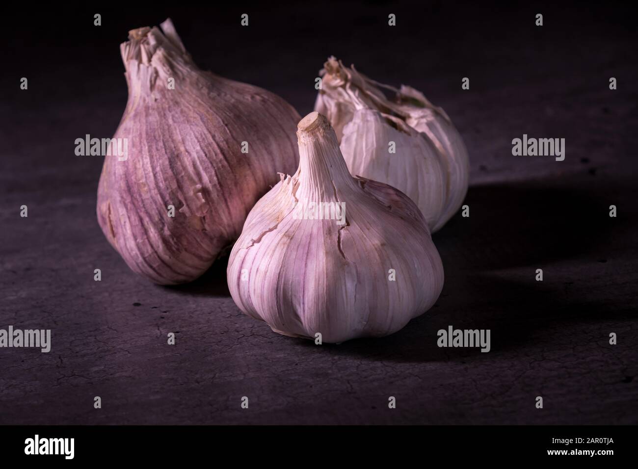 three large heads of pink garlic on a kitchen worktop Stock Photo - Alamy