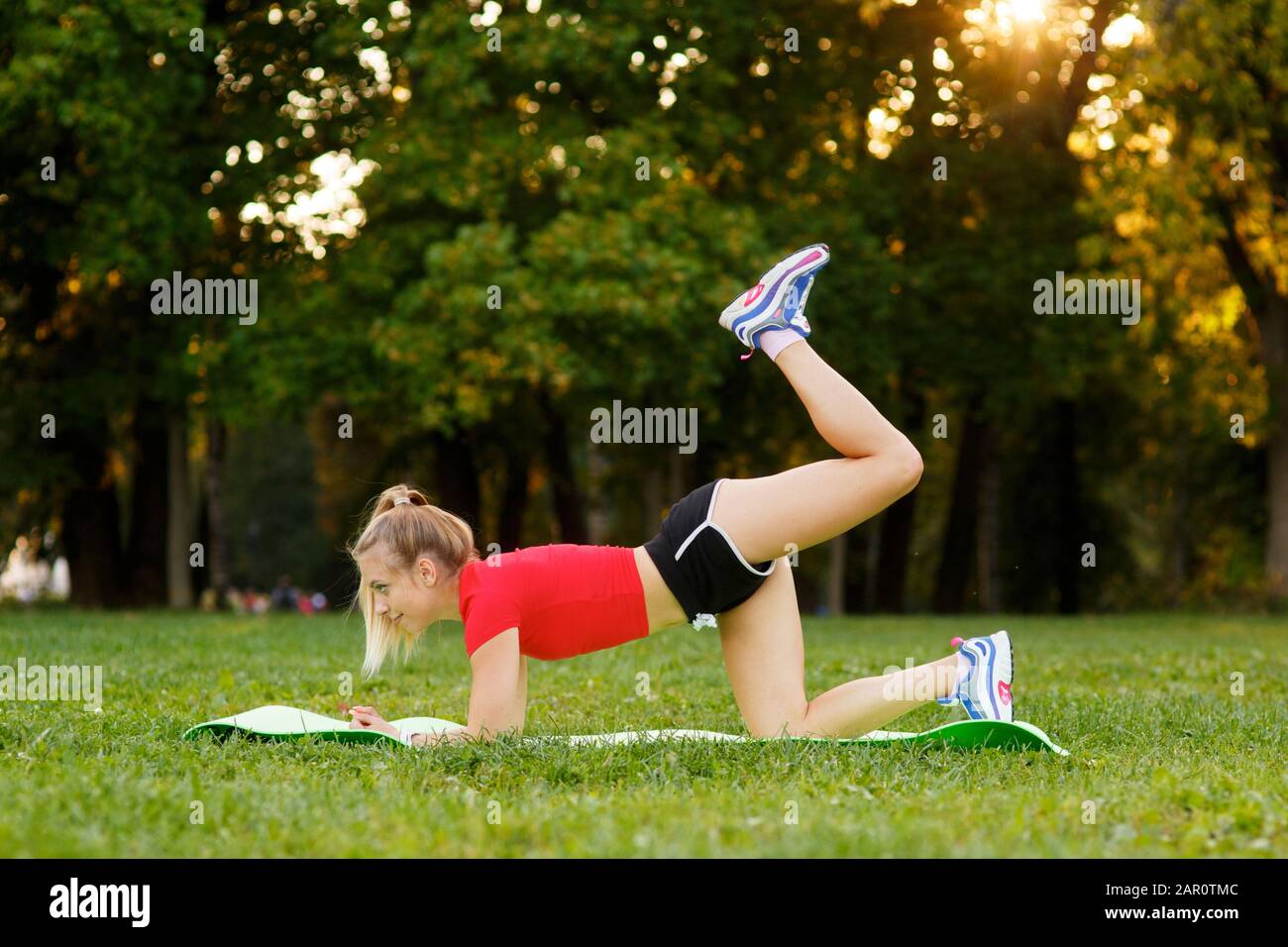Healthy young sportswoman doing the exercises on all fours arching back ...