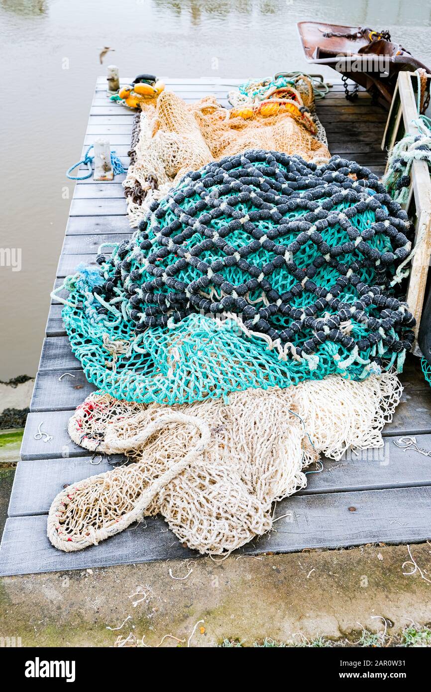 blue fishing net on a pontoon with its ropes and floats covered with ...
