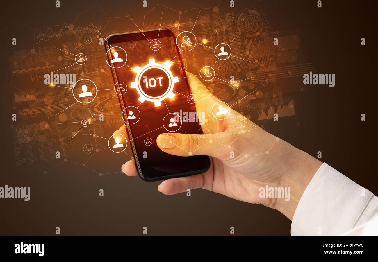 Female hand holding smartphone with IOT abbreviation, modern technology ...