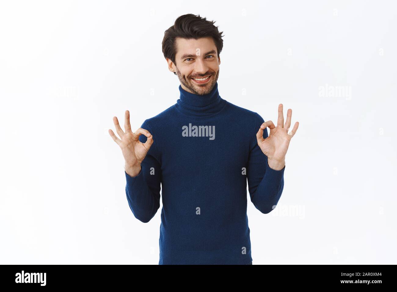 Relaxed and assured, assertive handsome bearded guy in blue high neck ...