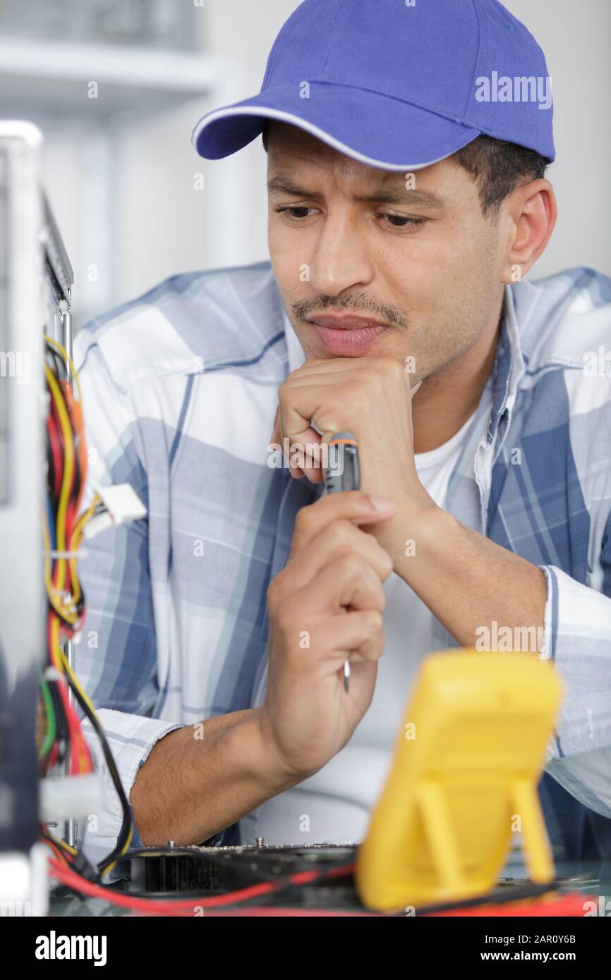 confused computer engineer looking at wires Stock Photo - Alamy