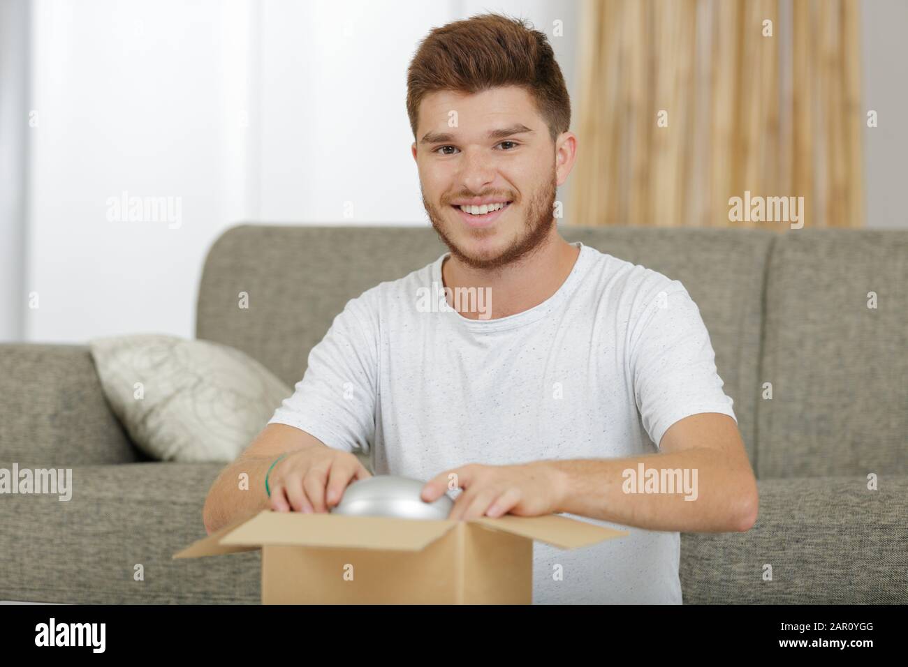 Young woman is opening a cardboard box hi-res stock photography and ...