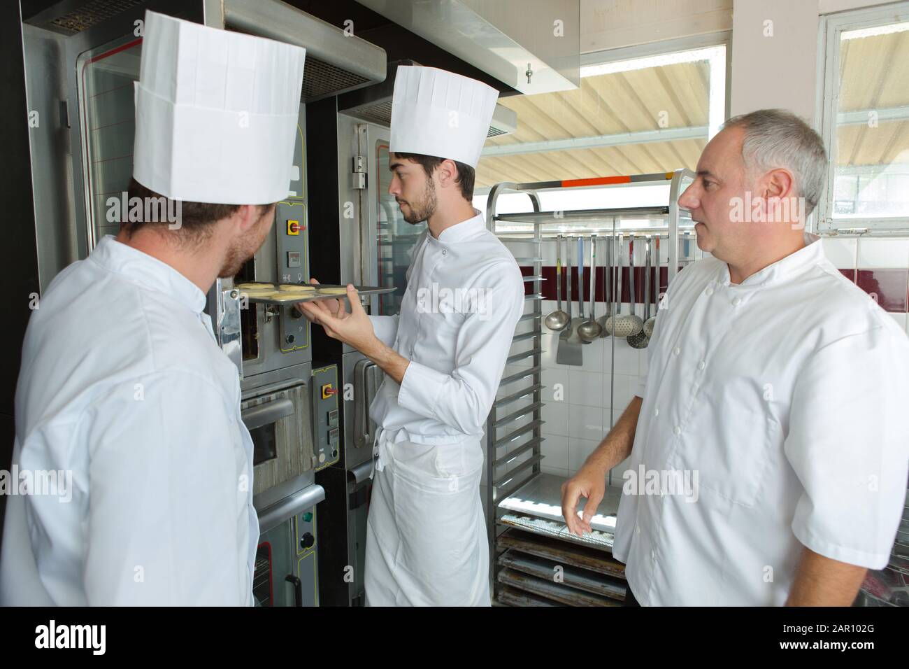 team of chefs working in a commercial kitchen Stock Photo - Alamy