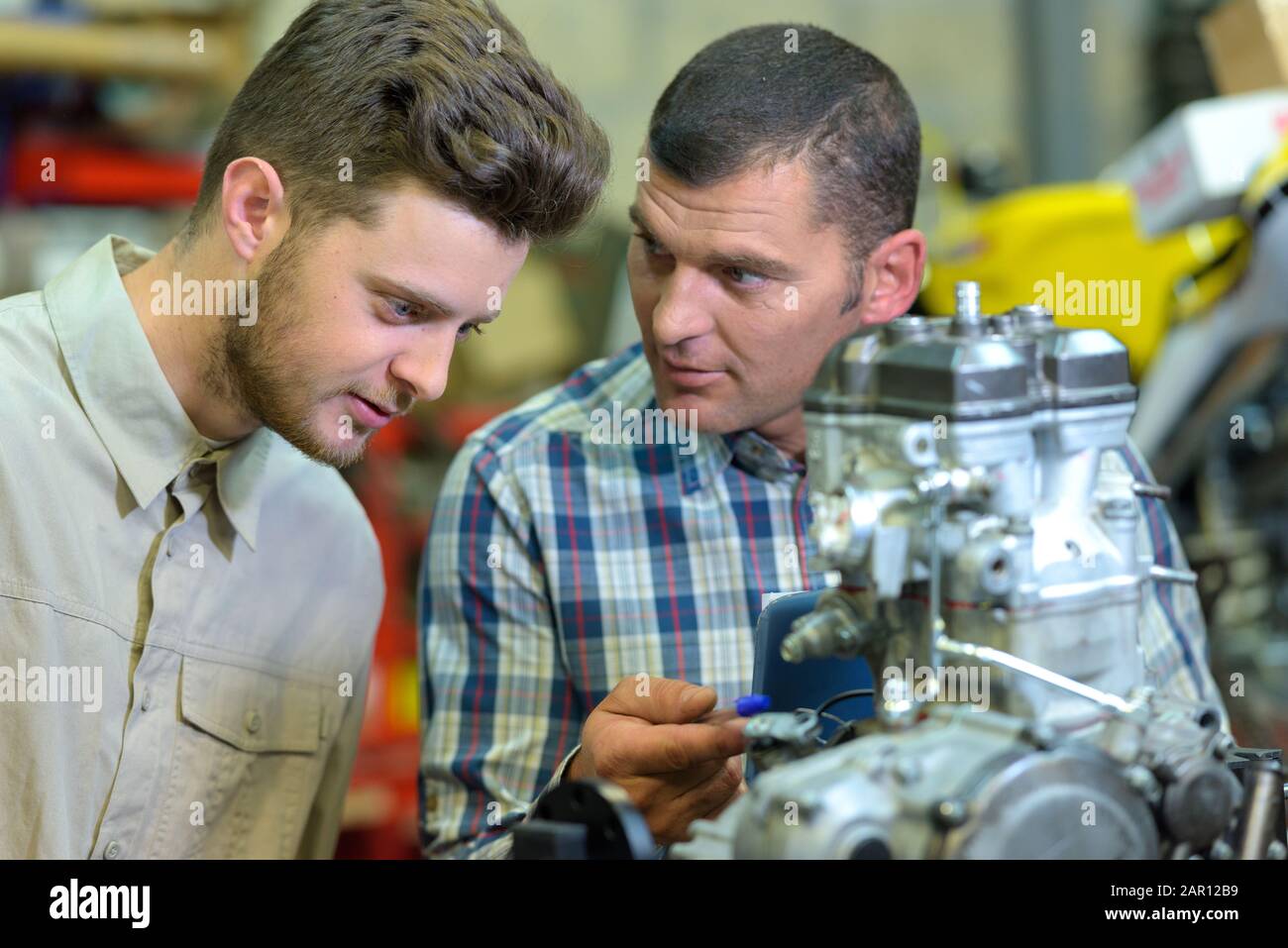 portrait of mechanics inspecting motorcycle motor Stock Photo - Alamy