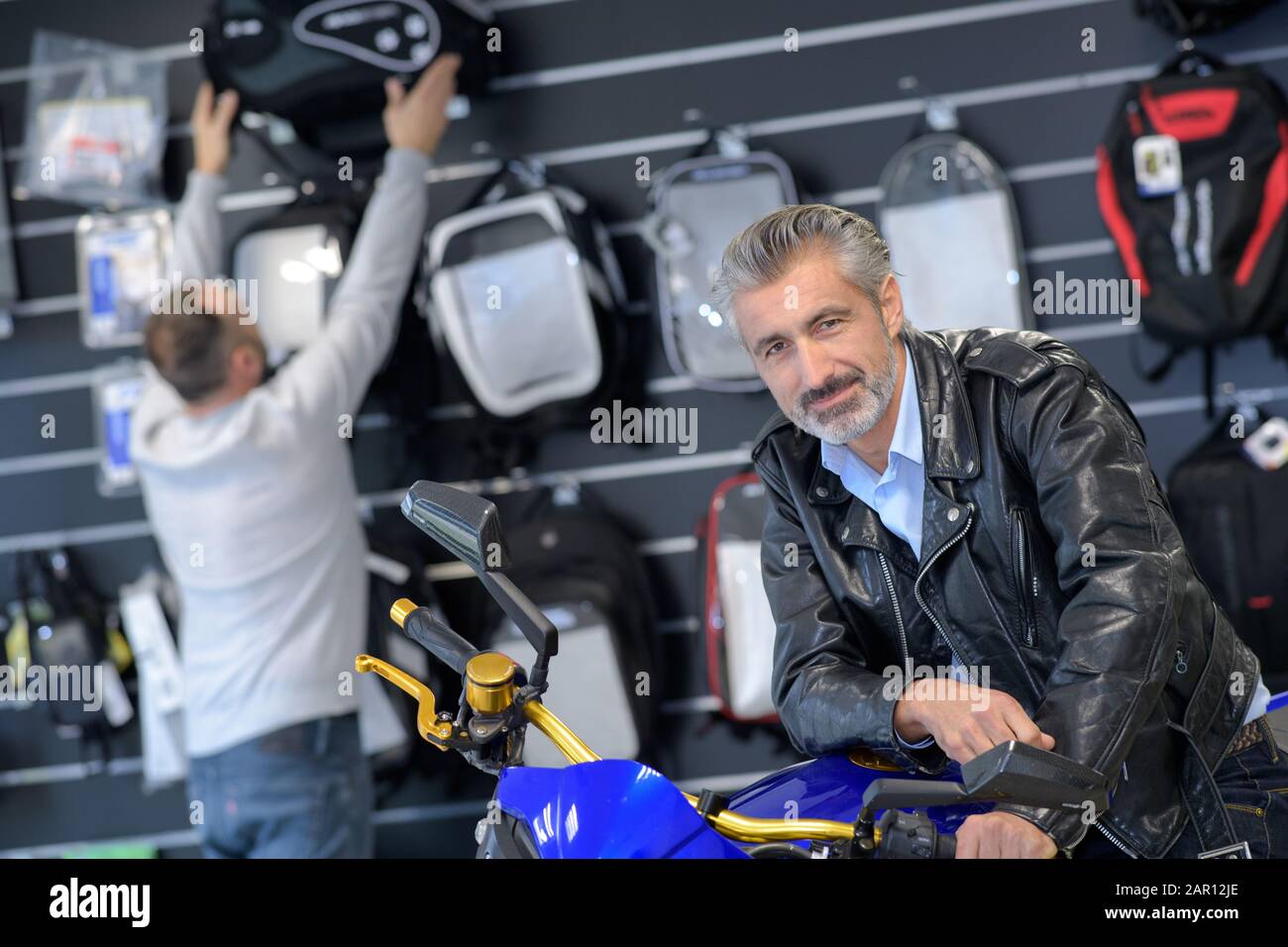 man customer holding his motorcycle at maintenance point Stock Photo ...