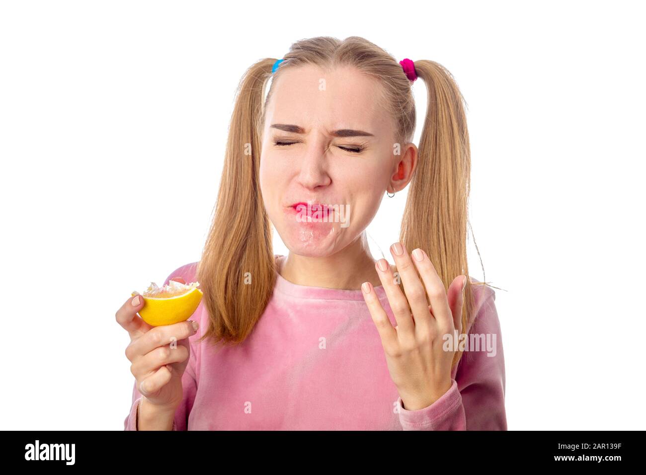 beautiful fun girl with lemon posing on white background, eats it ...