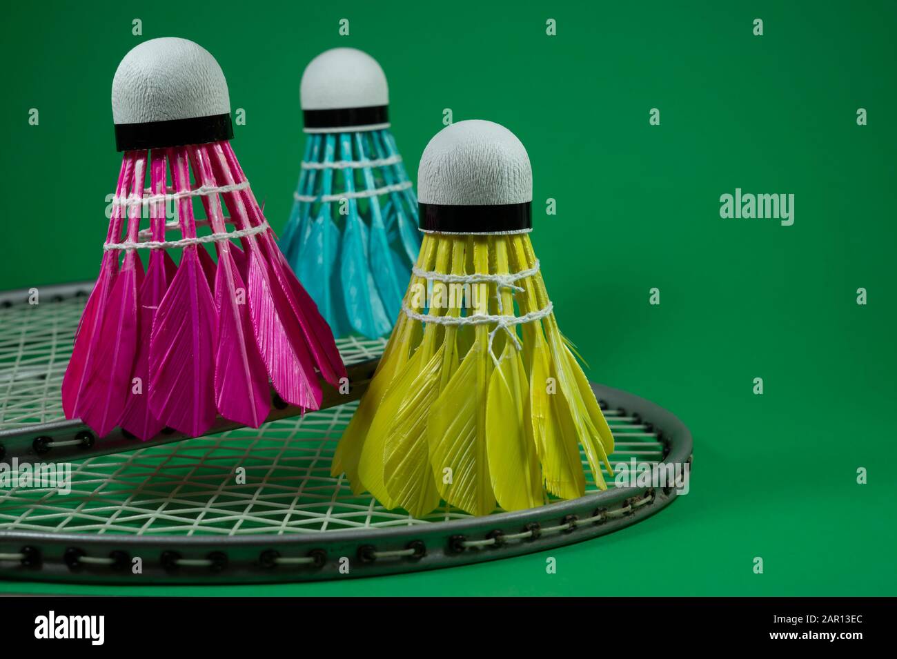 Badminton rackets and colorful feathered shuttlecocks in blue, yellow ...