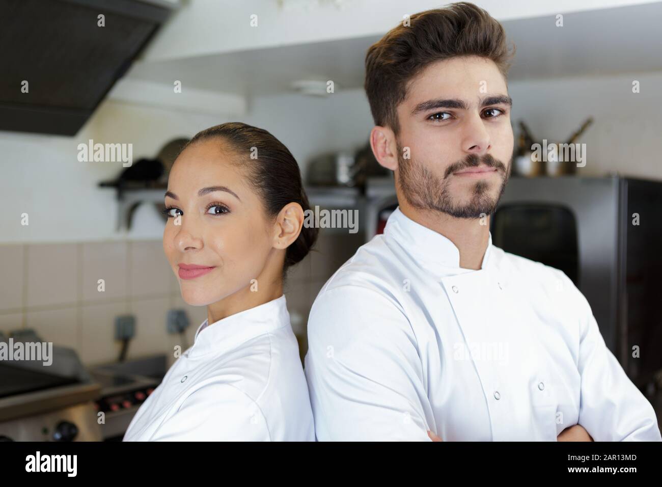 portrait of male and female chefs back to back Stock Photo - Alamy