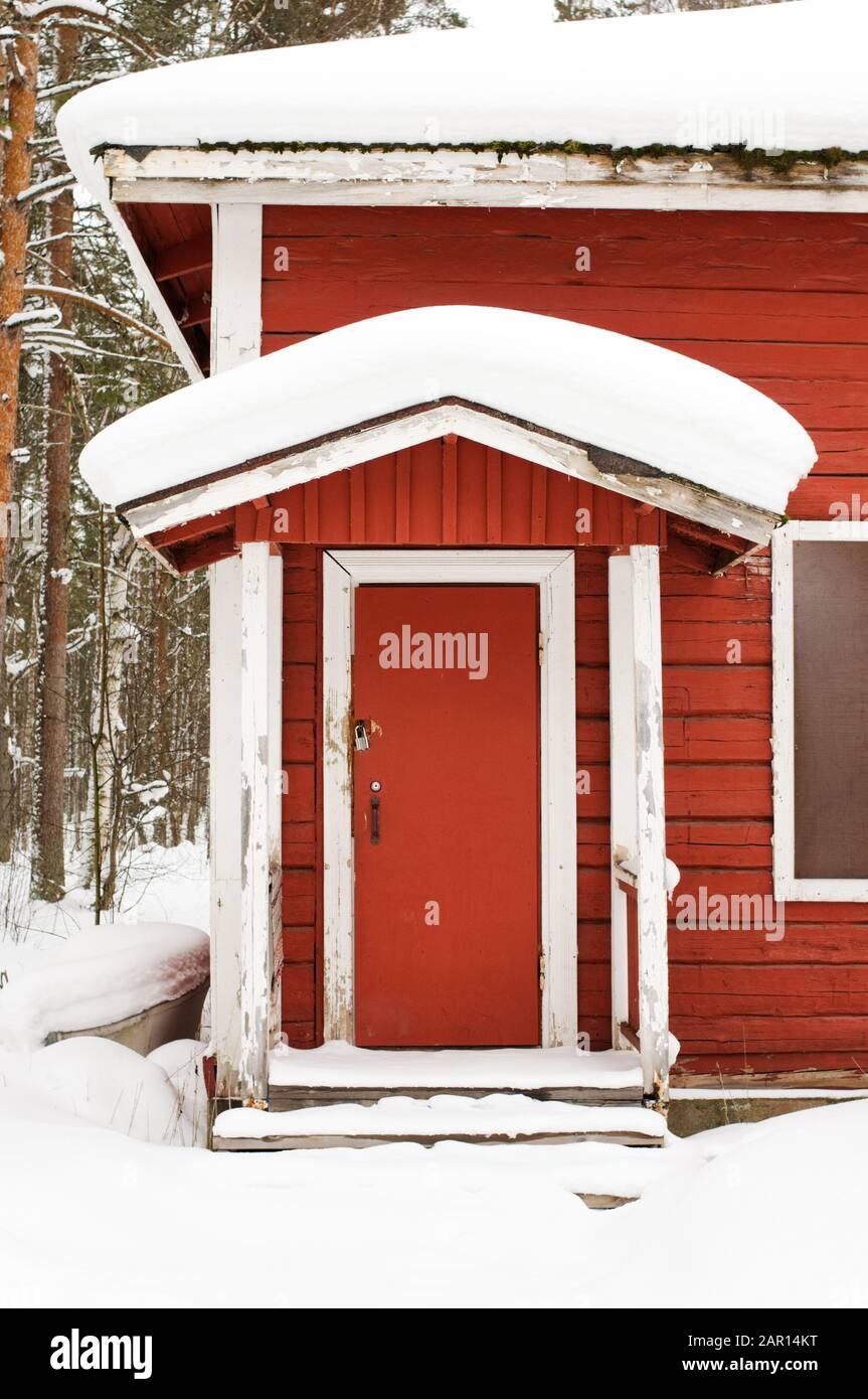 Door of an old wooden cottage in the woods. Snow covering roof and ...