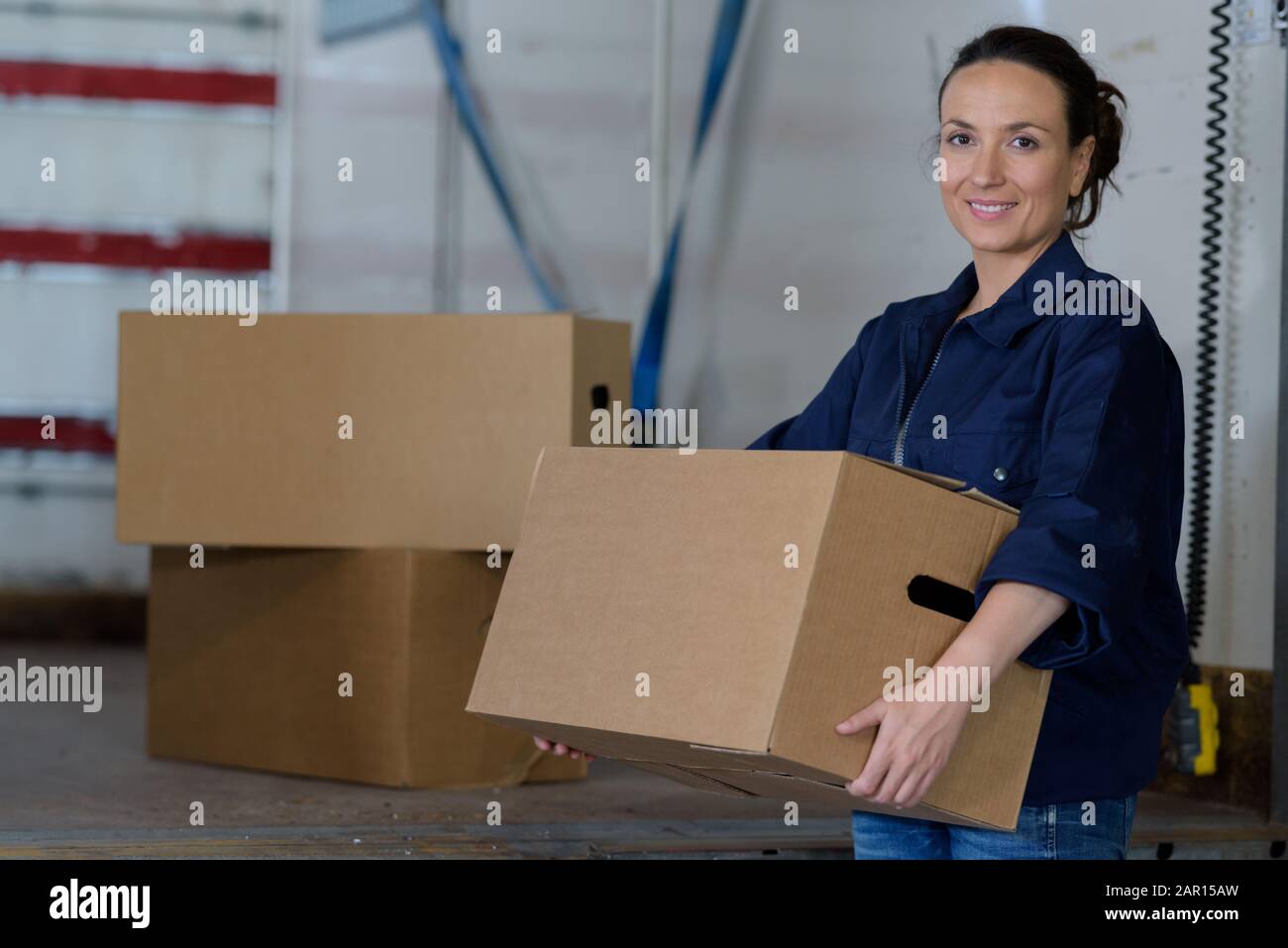 portrait of a woman moving boxes Stock Photo - Alamy