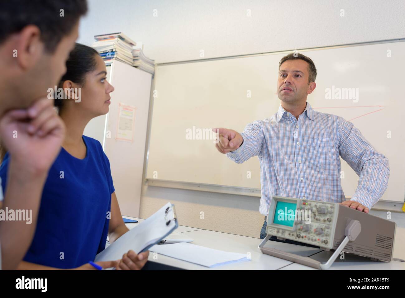 teacher pointing at the students in a classroom Stock Photo - Alamy