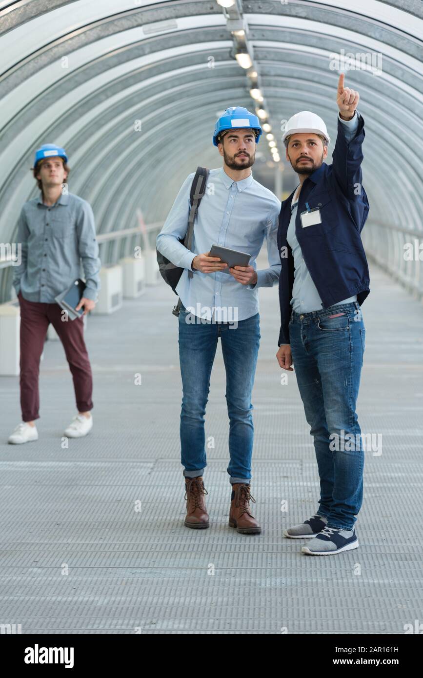 two engineers working outside with building background Stock Photo - Alamy