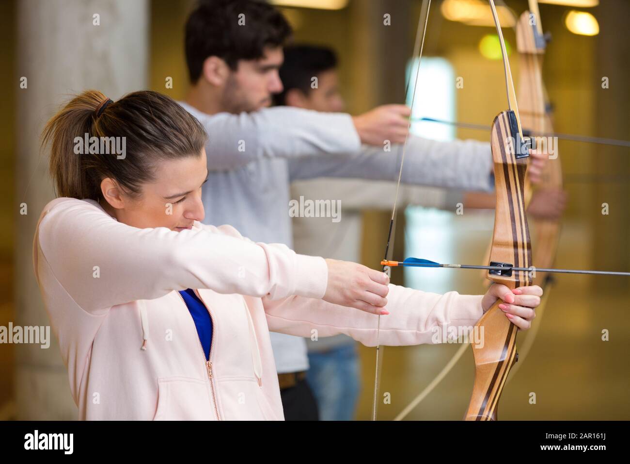 row of people aiming with their archery bows Stock Photo - Alamy