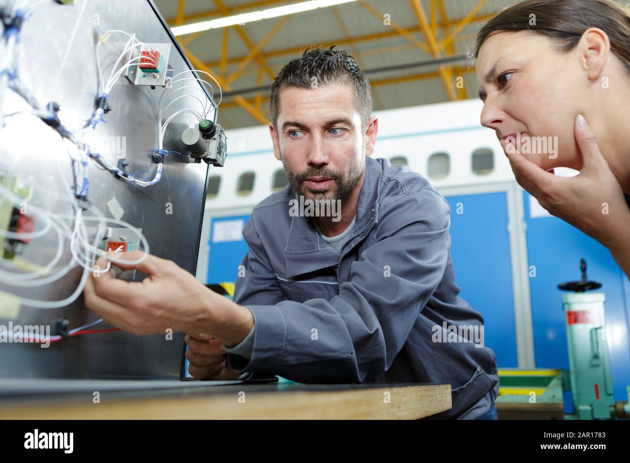 man and woman fixing a machine Stock Photo - Alamy