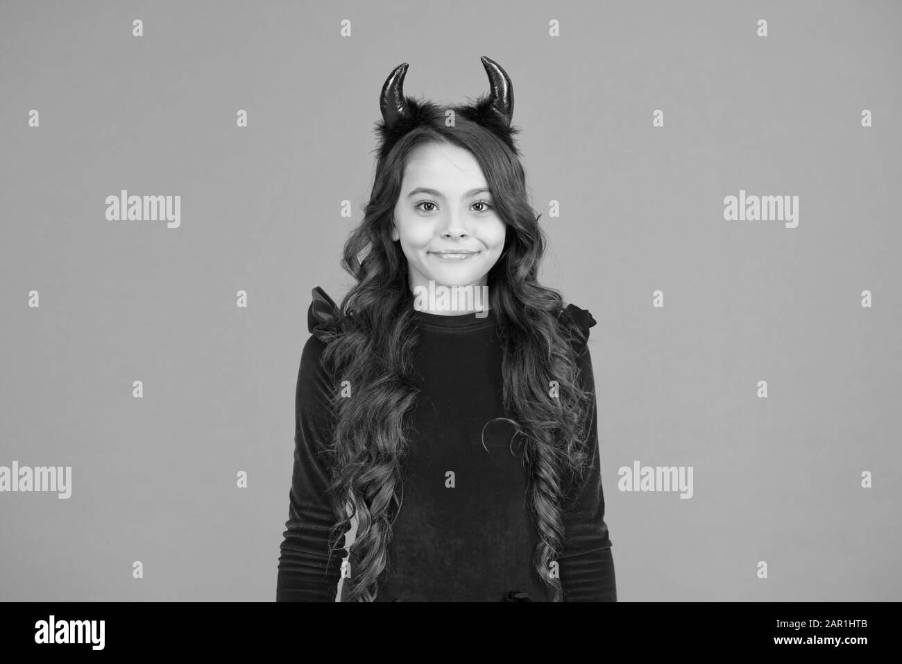 Little devil. Little girl red horns celebrate Halloween. Carnival ...