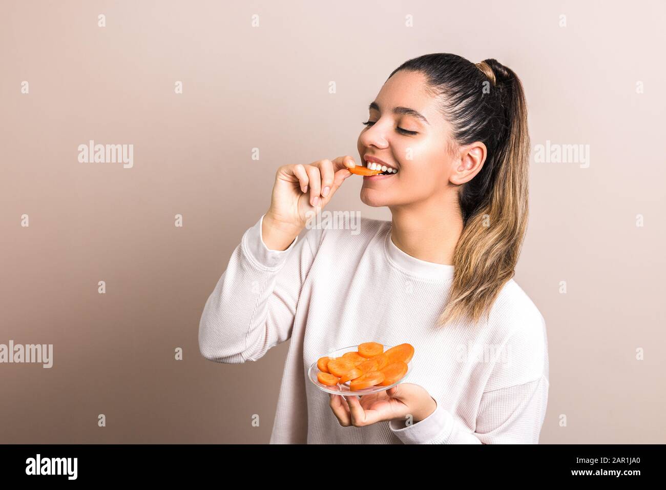 Attractive woman eating carrot hi-res stock photography and images - Alamy