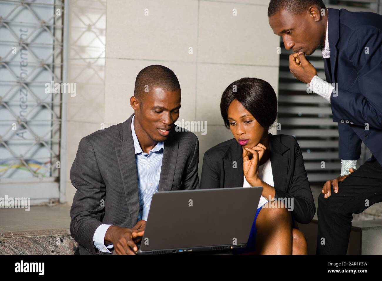 a business team sitting outside working together on laptop Stock Photo ...