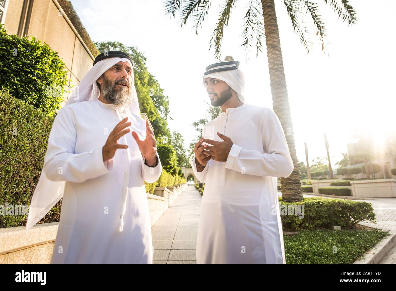Two businessmen with traditional emirates clothes meeting in Dubai ...