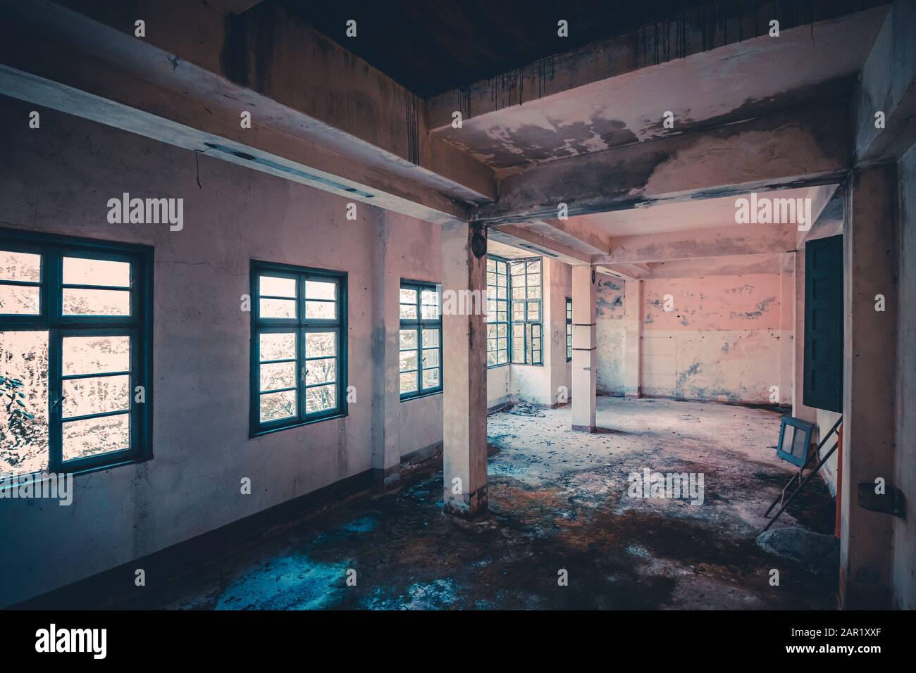 old damaged ruin of a house, inside a house with windows and pillars ...