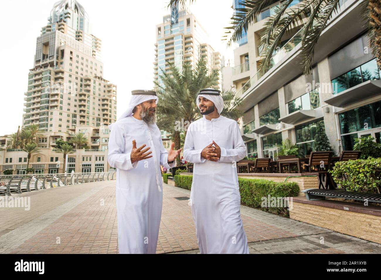 Two businessmen with traditional emirates clothes meeting in Dubai ...