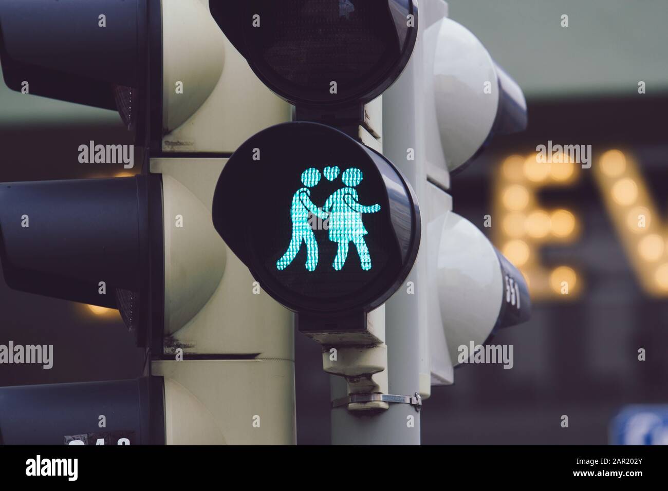 Closeup shot of a traffic light showing a man and a woman holding hands ...