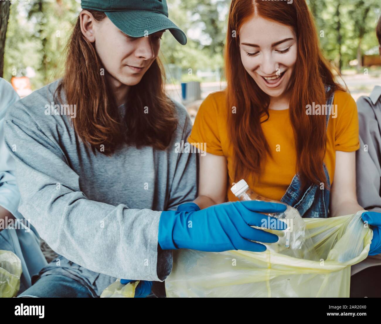 Man and Woman picking up trash from the park. They collecting the ...