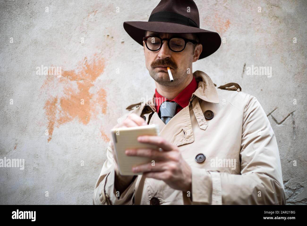 Detective taking notes in a ghetto Stock Photo - Alamy