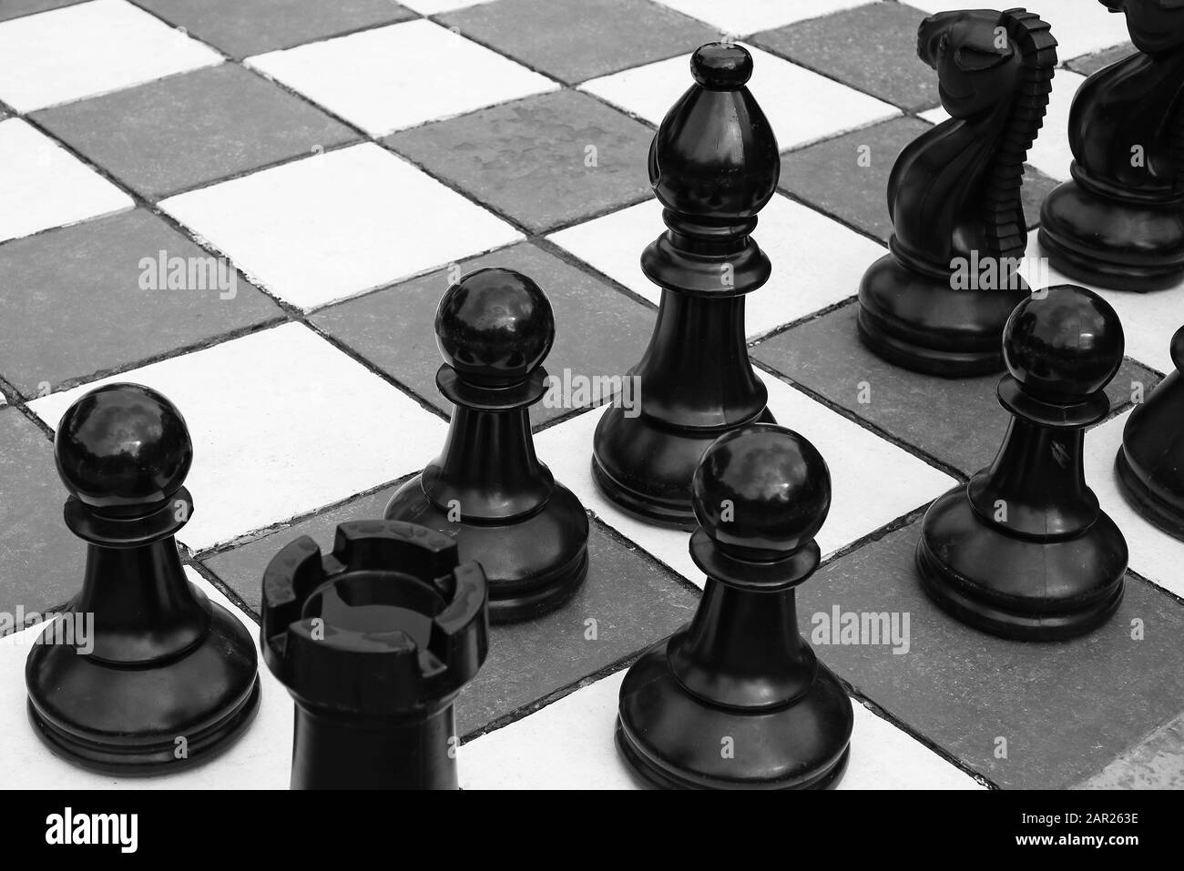 High angle grey scale shot of the big chess pieces on the chess board ...