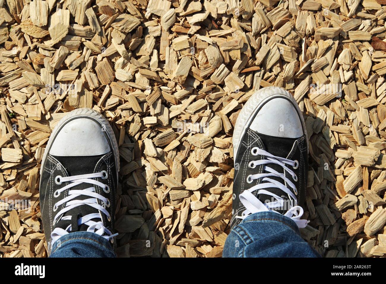 High angle shot of a person's feet standing on the ground covered with ...