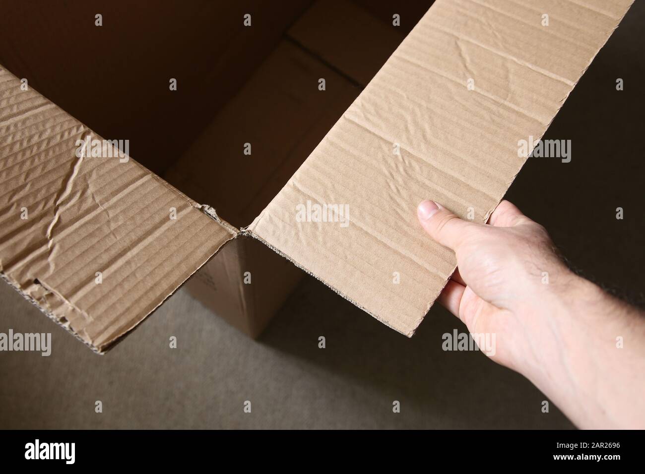 High angle shot of person's hand opening an empty cardboard box Stock ...