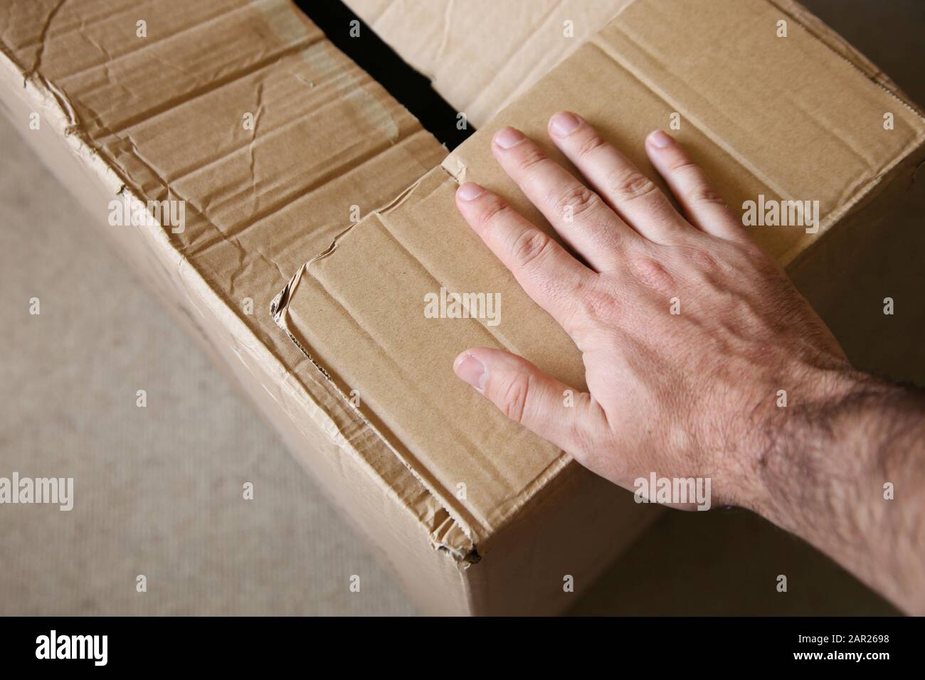 High angle shot of a person's hand closing a cardboard box Stock Photo ...