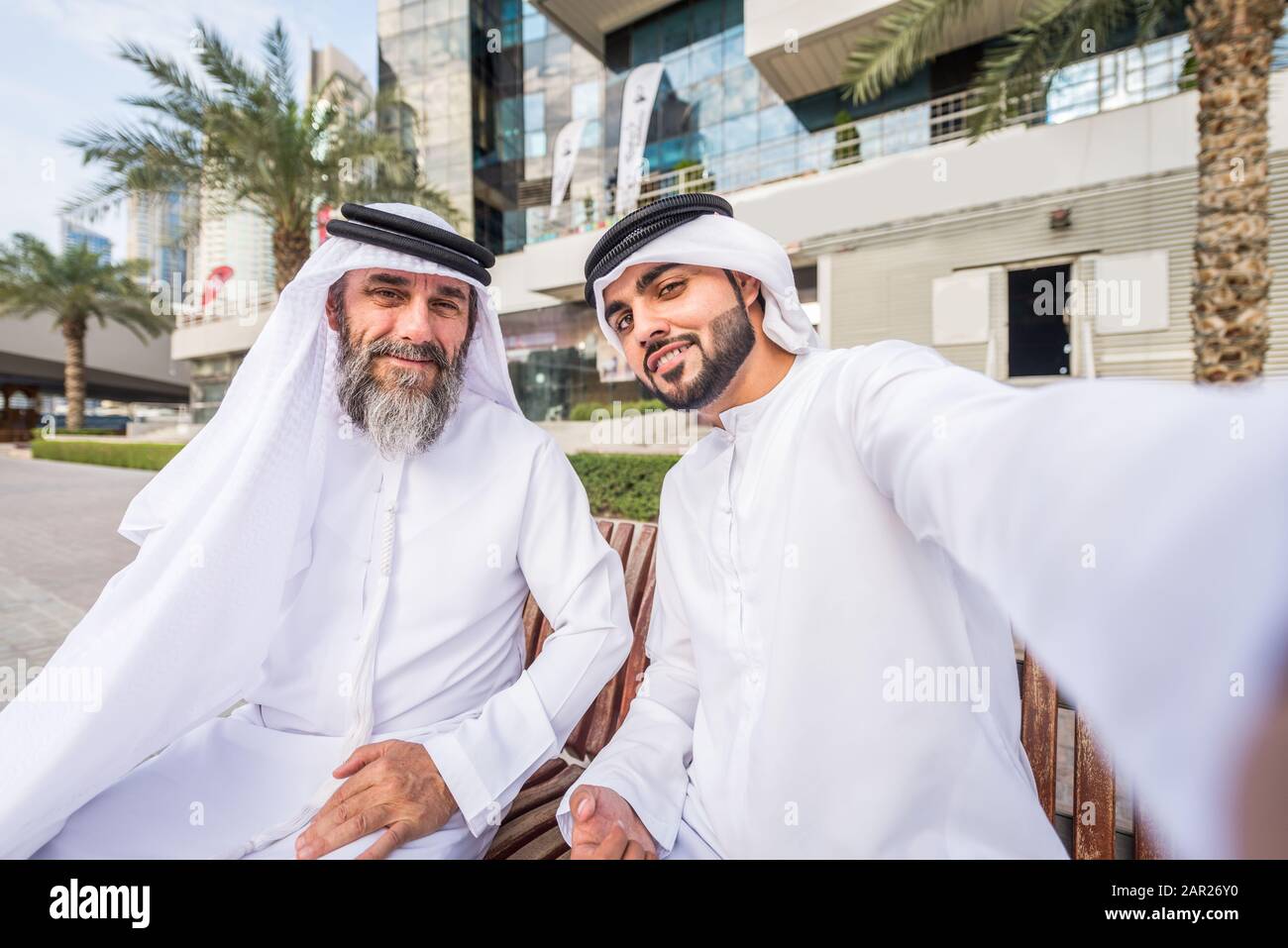 Two businessmen with traditional emirates clothes meeting in Dubai ...