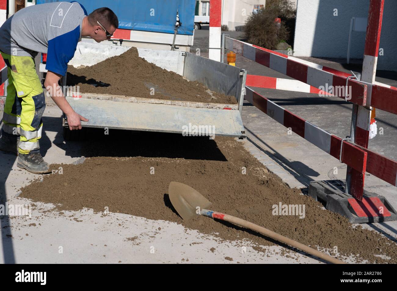 Young construction worker on construction site closes tailgate of a ...
