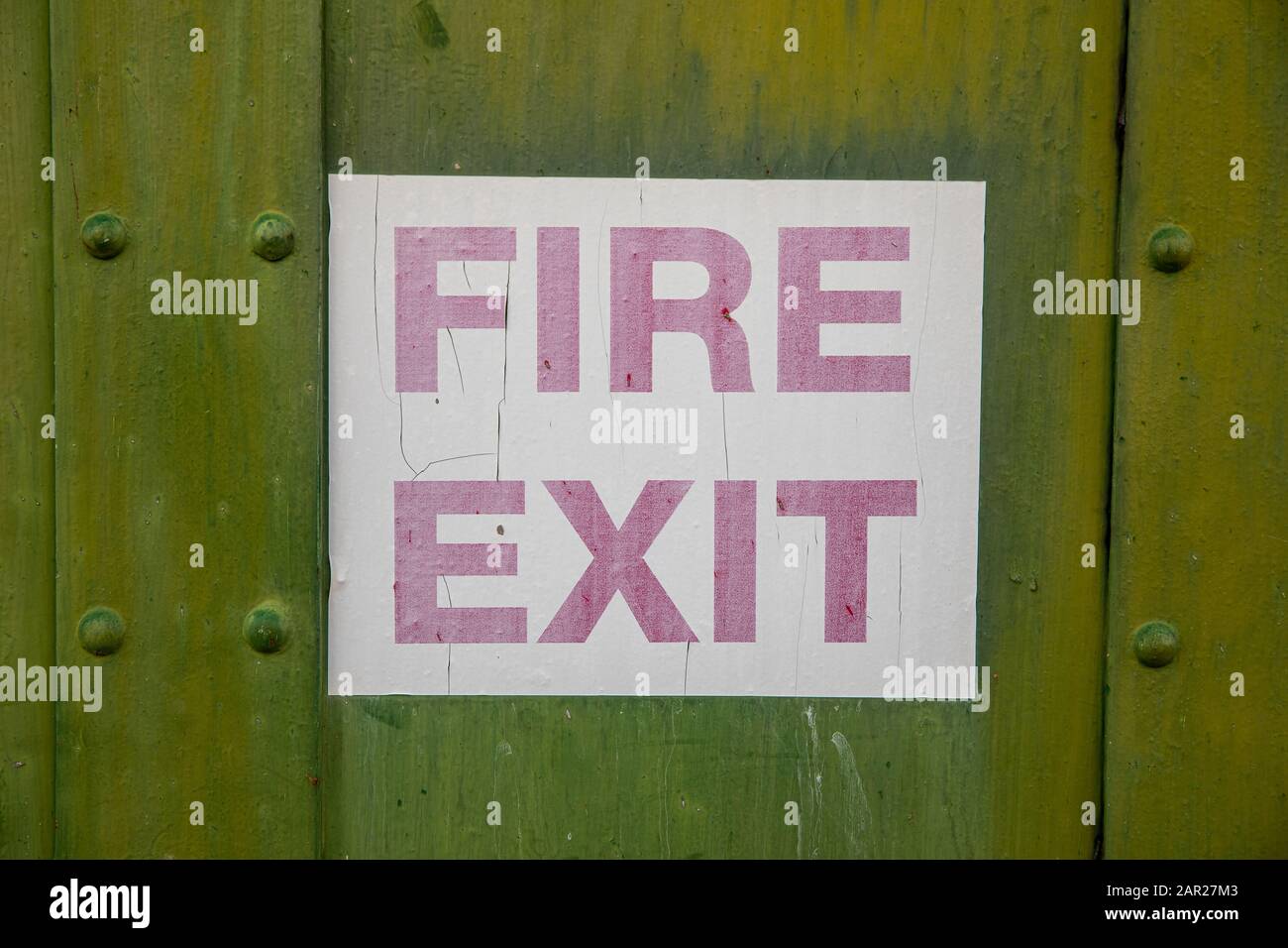 Faded fire exit sign against a gree background Stock Photo - Alamy
