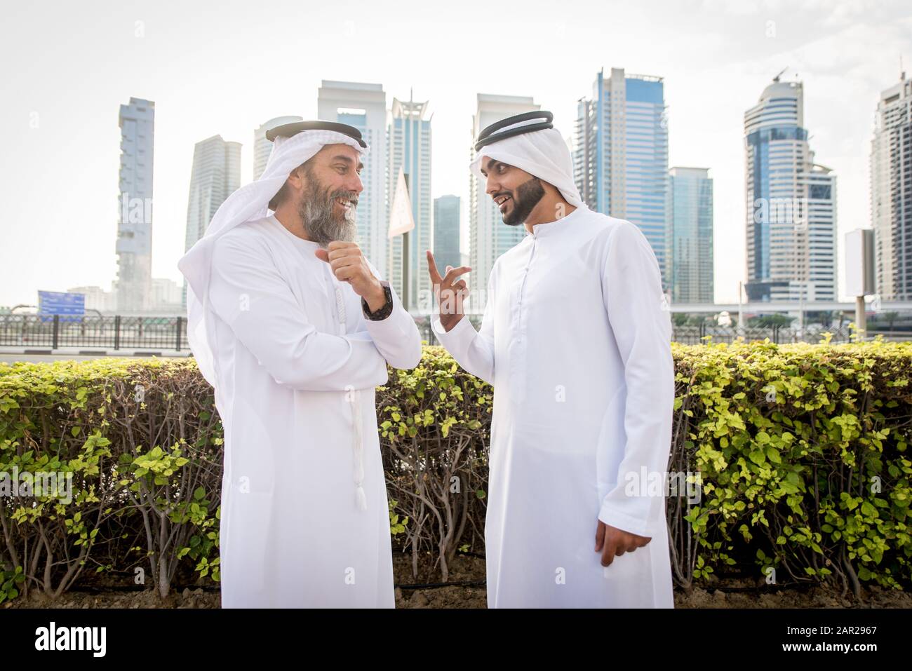 Two businessmen with traditional emirates clothes meeting in Dubai ...