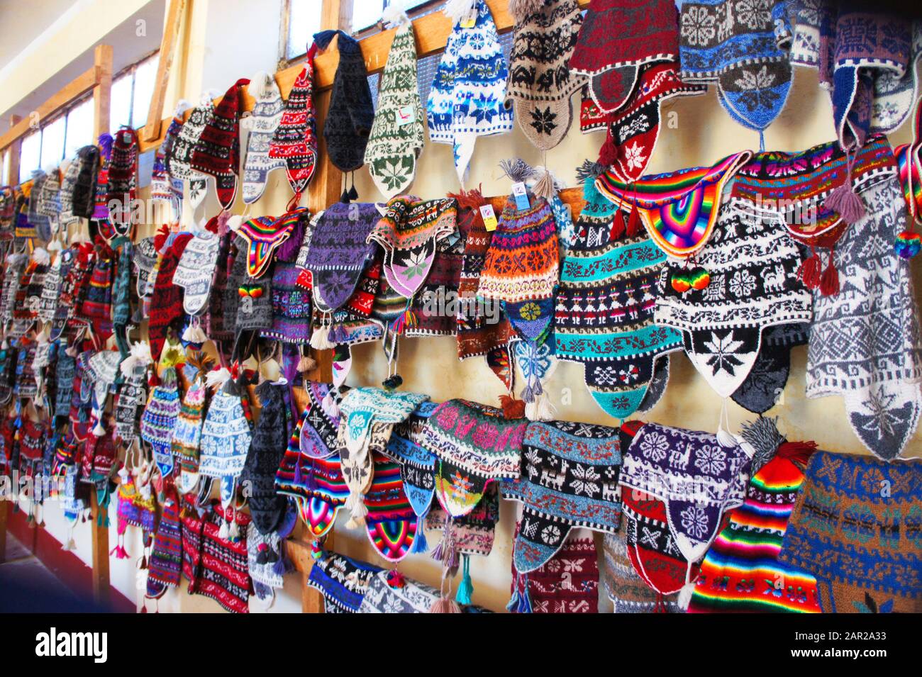Colorful traditonal hand knitted Peruvian hats line the wall of a ...