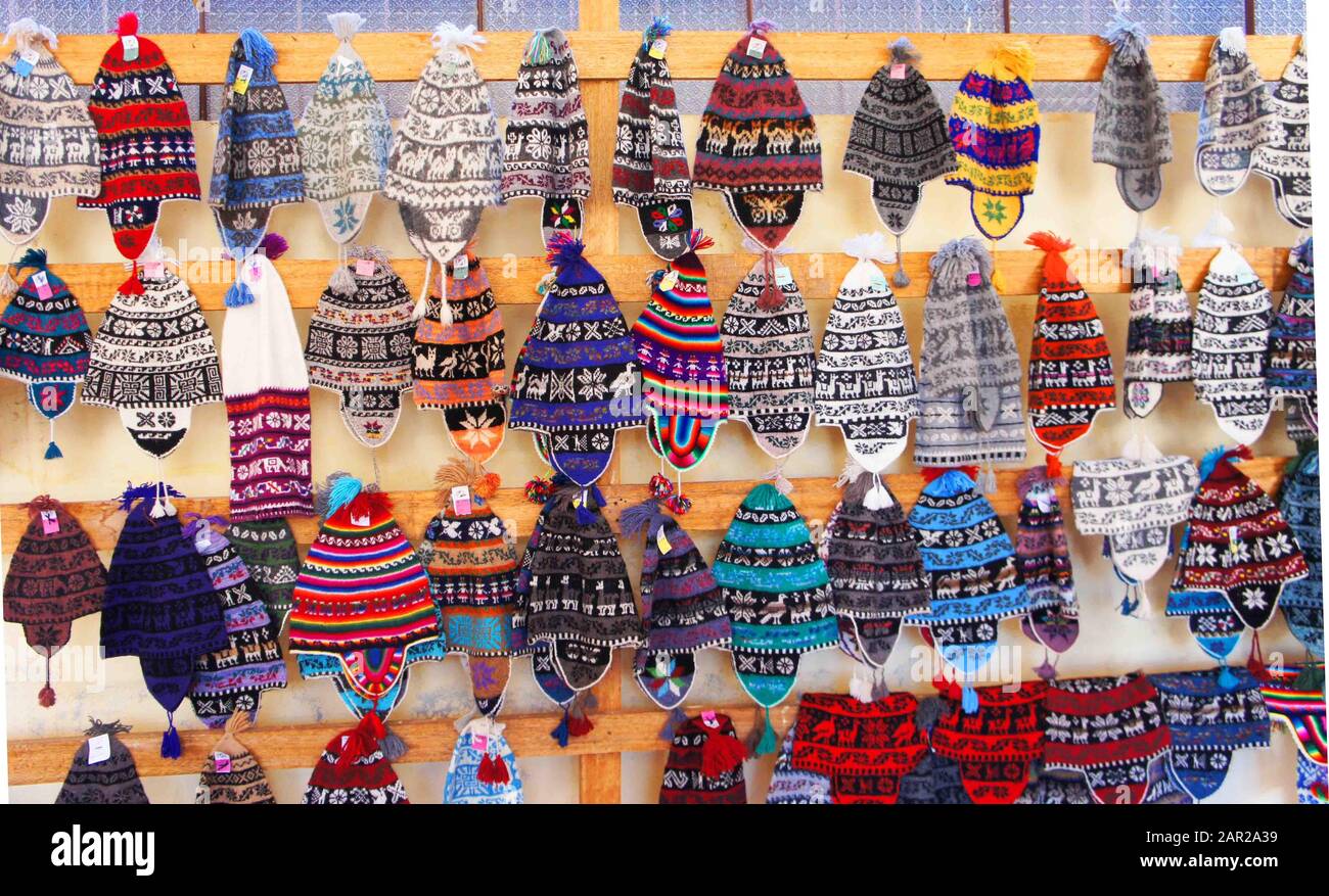 Colorful traditonal hand knitted Peruvian hats line the wall of a ...