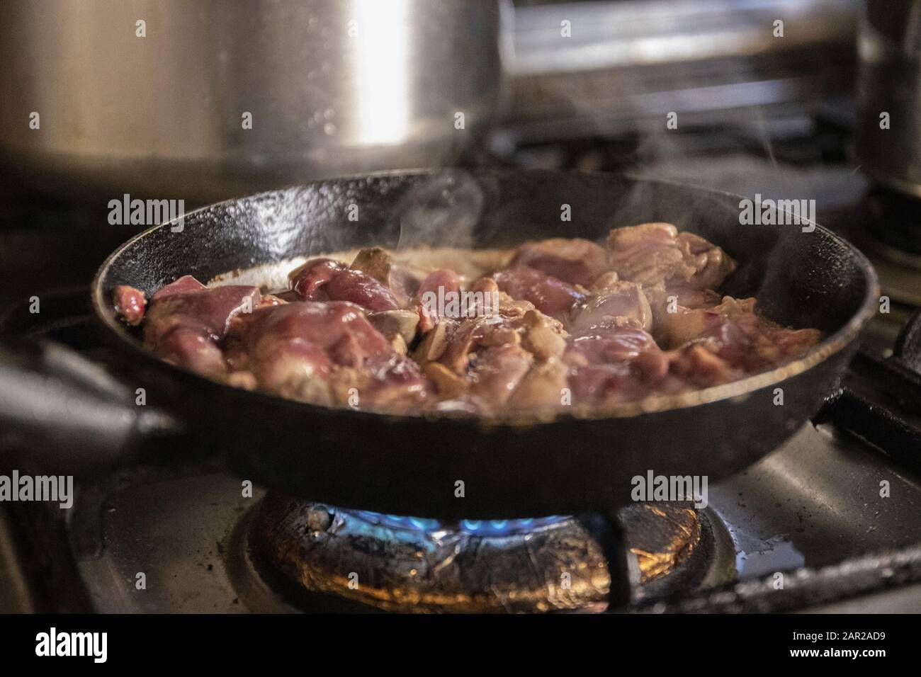 the fresh red pieces sheep meat was cooking in the kitchen by housewife ...