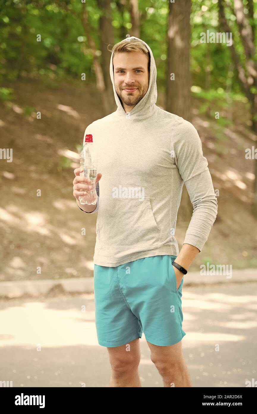 Stay hydrated. Athlete drink water after training in park. Man athlete ...