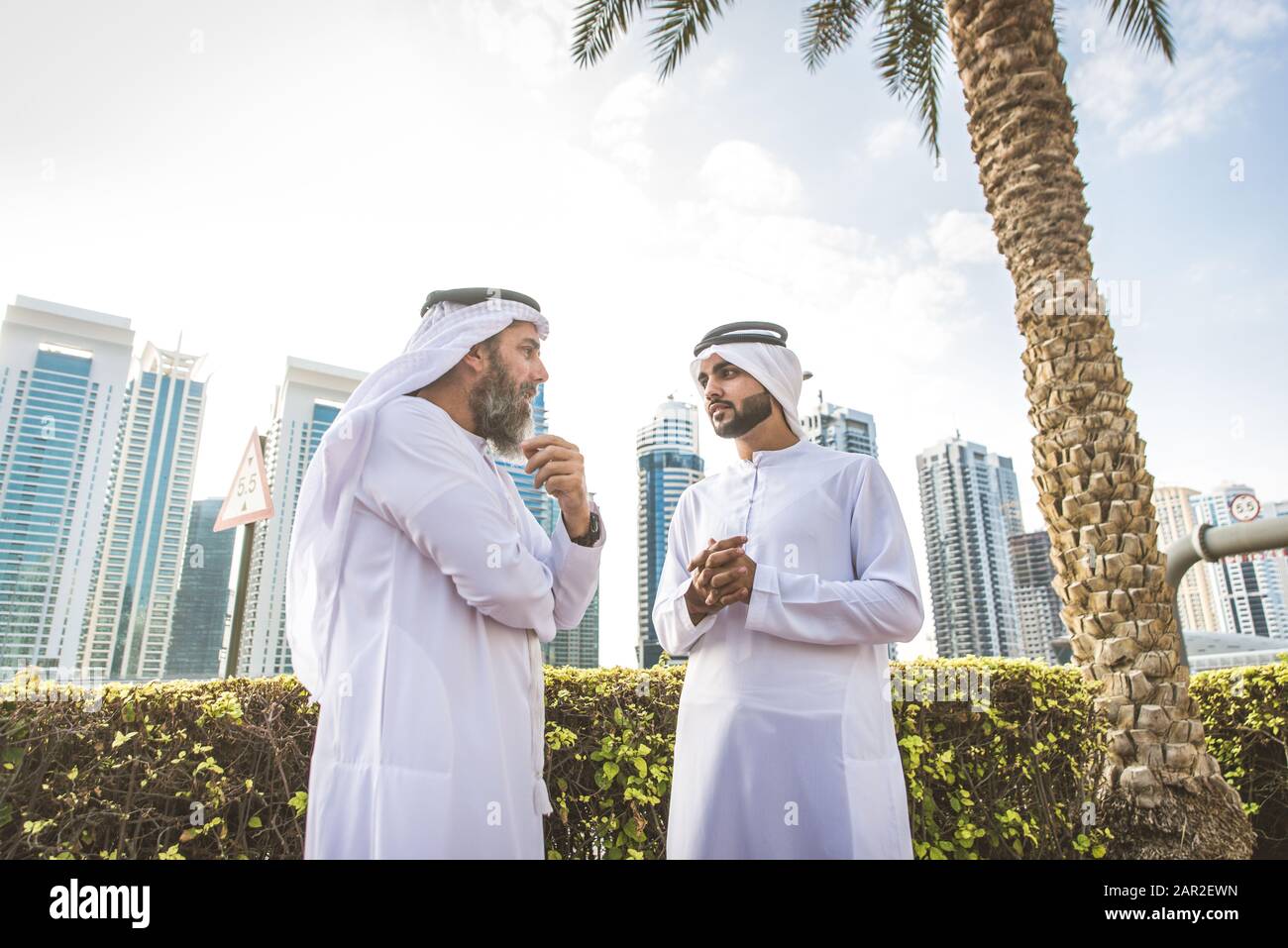 Two businessmen with traditional emirates clothes meeting in Dubai ...