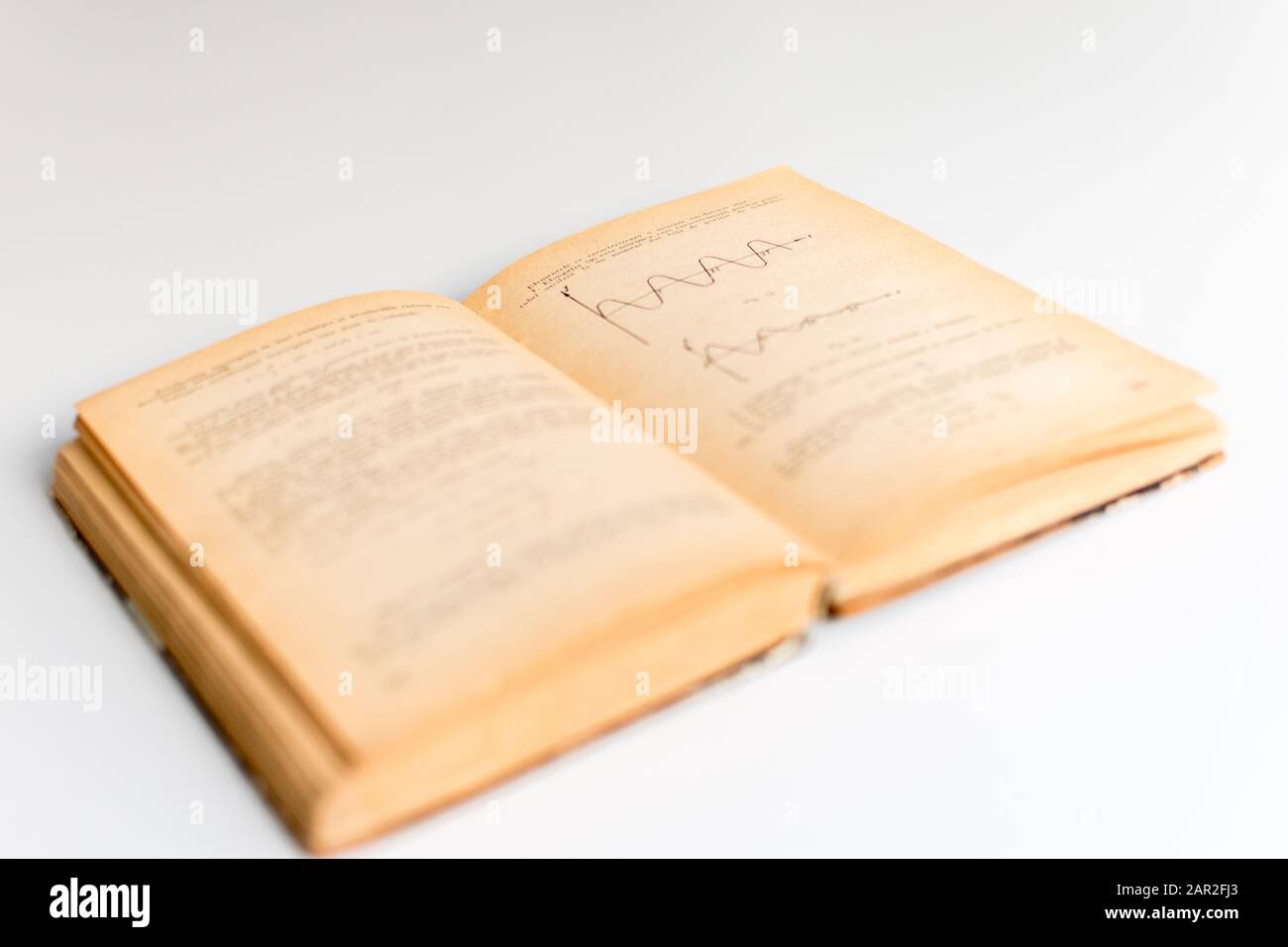 Close up shot of an open old science book containing equations and ...