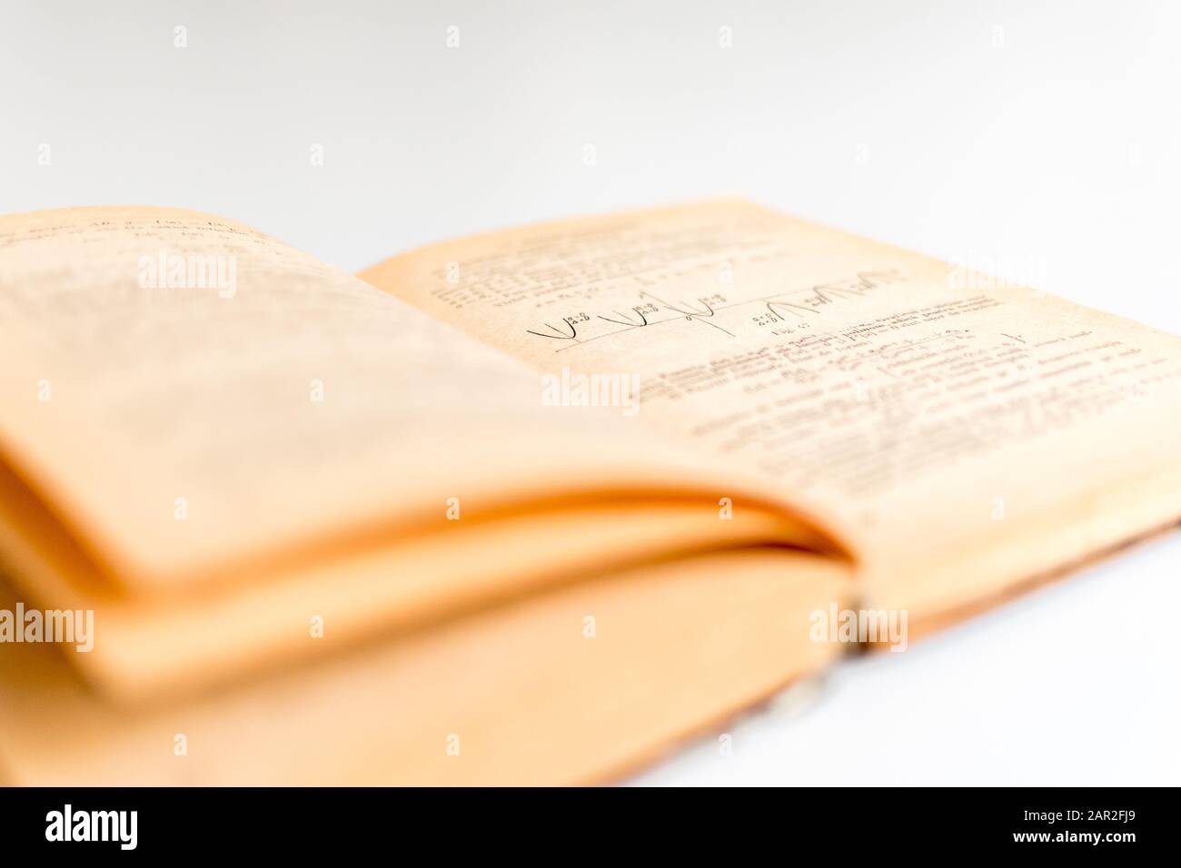 Close up shot of an open old science book containing equations and ...