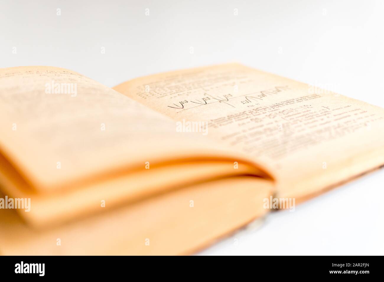 Close up shot of an open old science book containing equations and ...