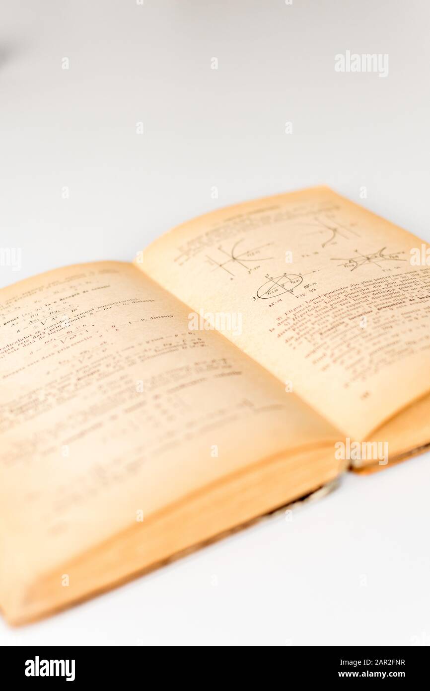 Close up shot of an open old science book containing equations and ...