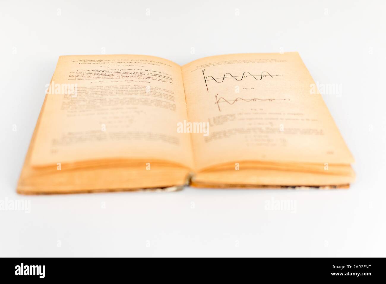 Close up shot of an open old science book containing equations and ...