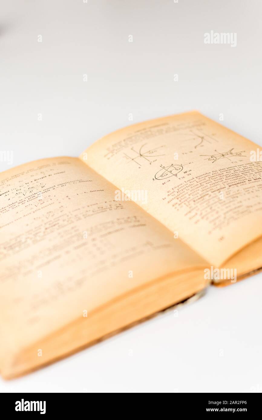 Close up shot of an open old science book containing equations and ...