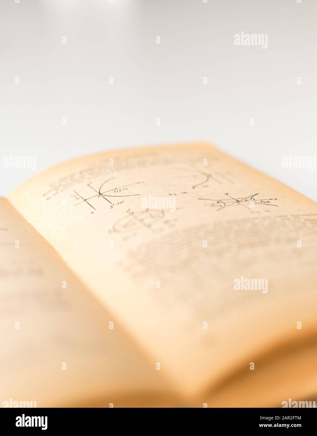 Close up shot of an open old science book containing equations and ...